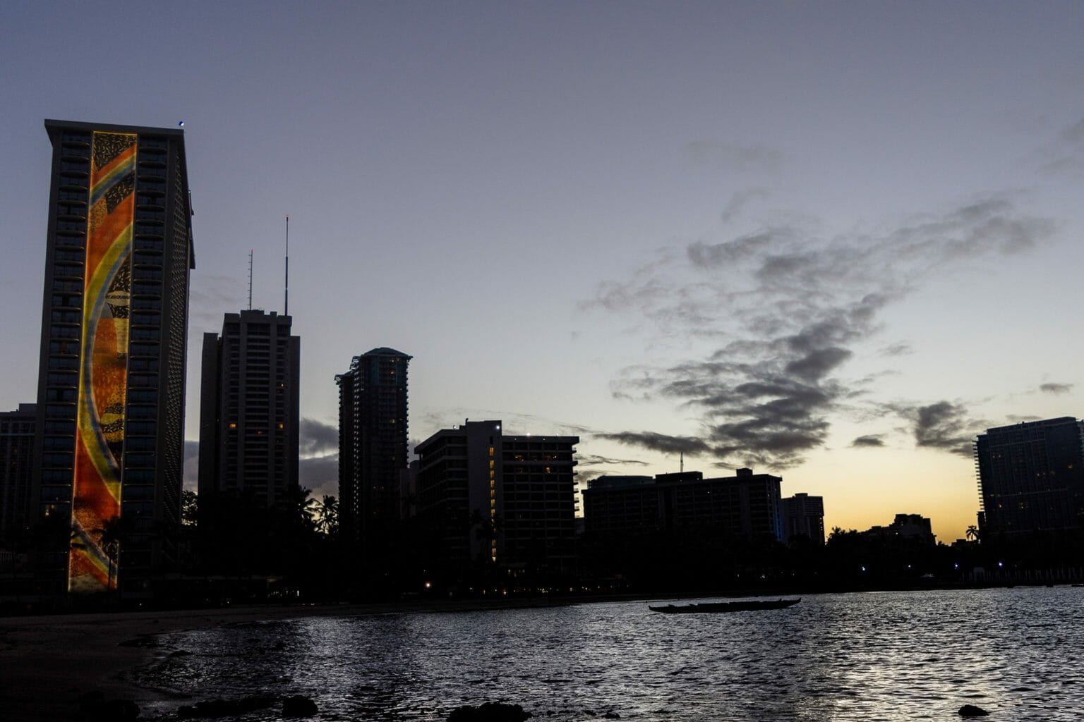 Lone surfer heads out at first light in Honolulu for early morning runs